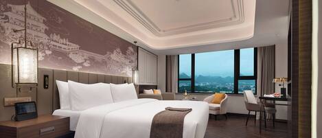 Quarto de hotel moderno com uma cama grande, uma escrivaninha e vista para a cidade.