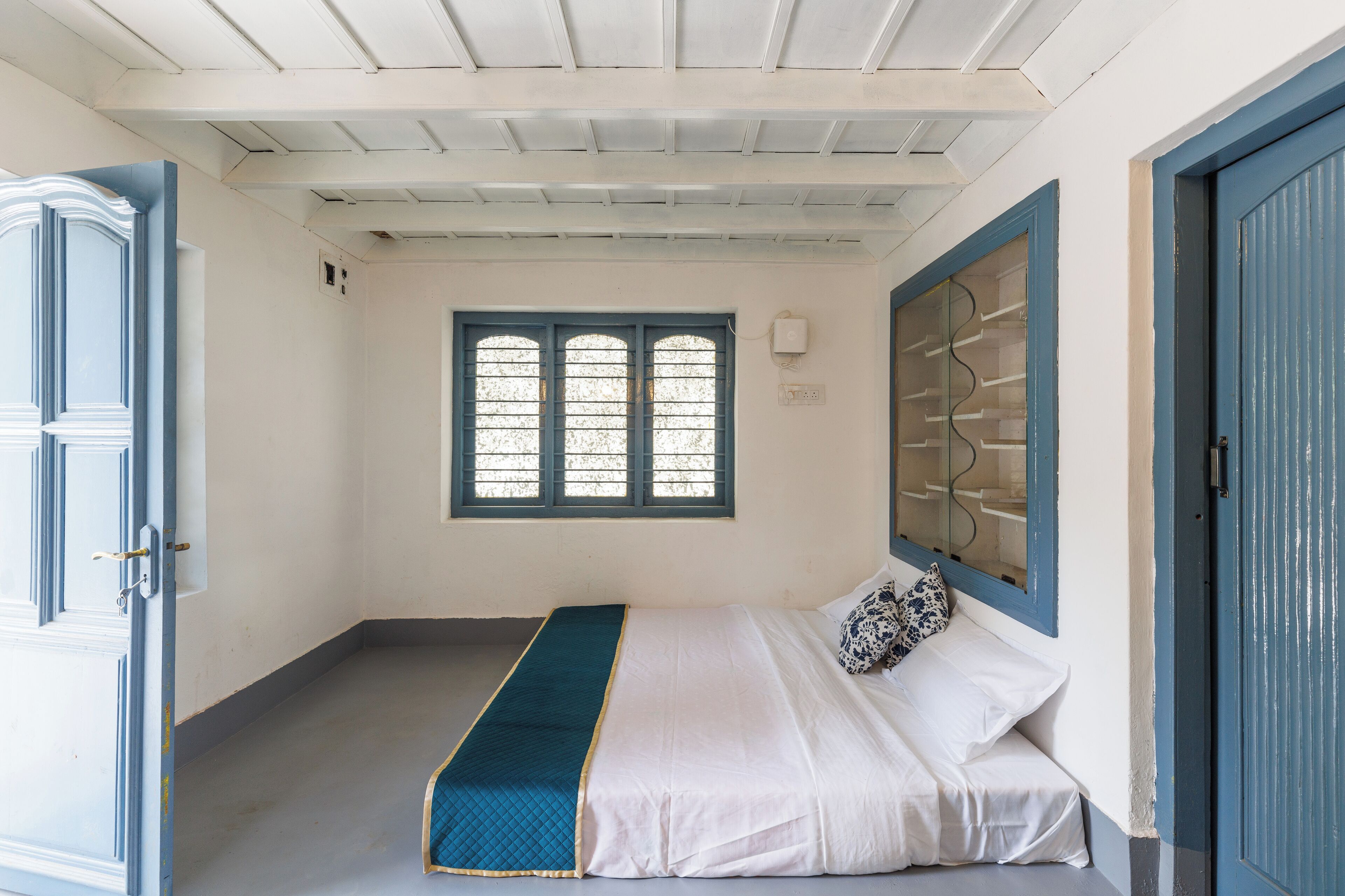 Quarto com uma cama, janela e porta.
