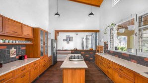 Uma cozinha moderna com armários de madeira, uma ilha central e iluminação pendente.