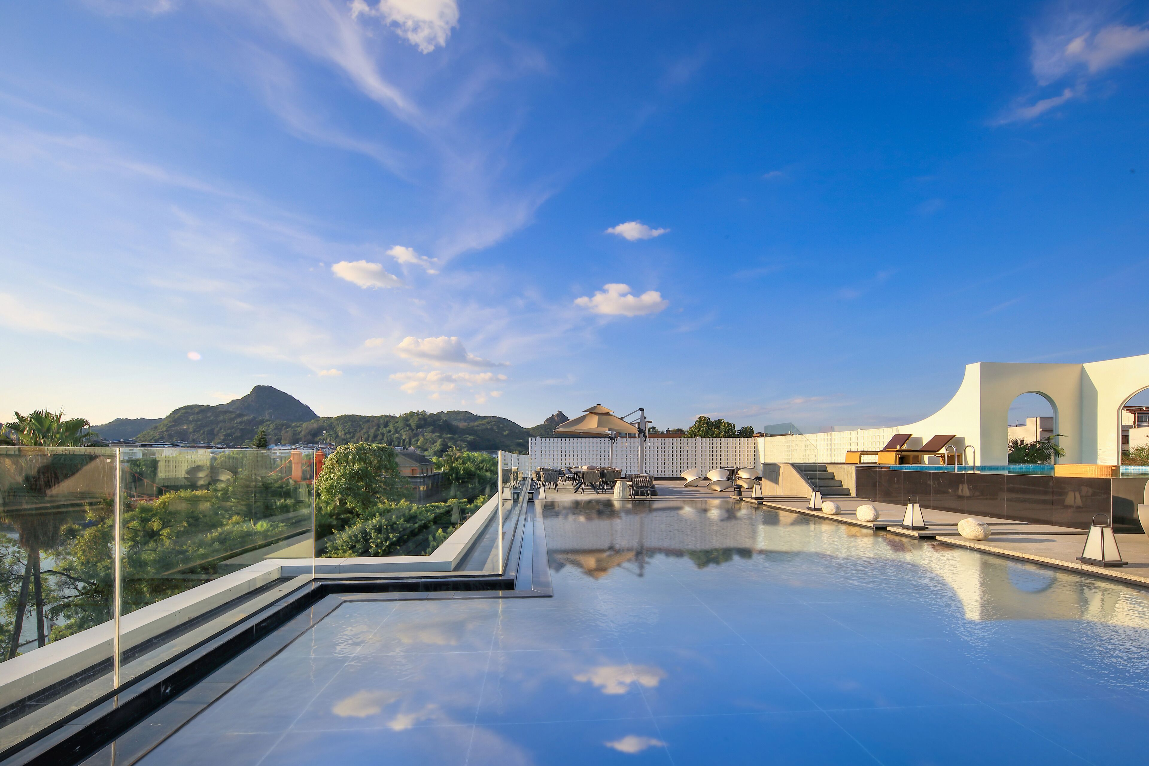 Piscina no terraço com vista desobstruída de montanhas e paisagem urbana.