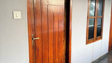 Uma porta de madeira com puxador de latão e janela com moldura de madeira.
