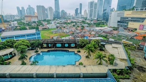 Paisagem urbana com edifícios modernos altos, uma piscina e uma combinação de estruturas residenciais e comerciais.