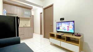 Uma sala de estar moderna com televisão de tela plana, um sofá e um móvel de entretenimento de madeira.