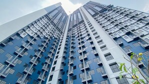 Um edifício alto com uma grade de varandas e janelas.