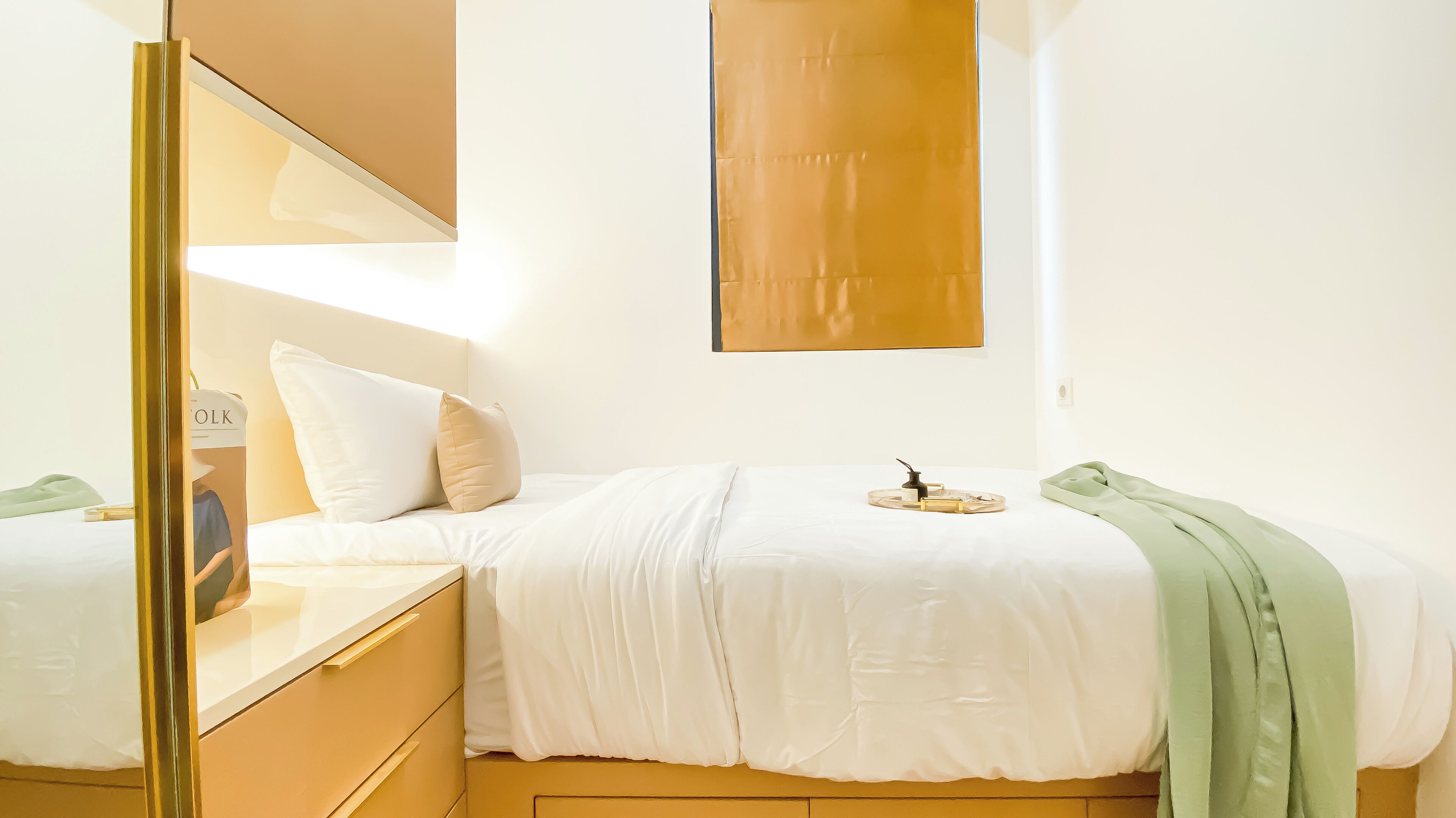 Quarto bem arrumado com cama, mesa de cabeceira e espelho.