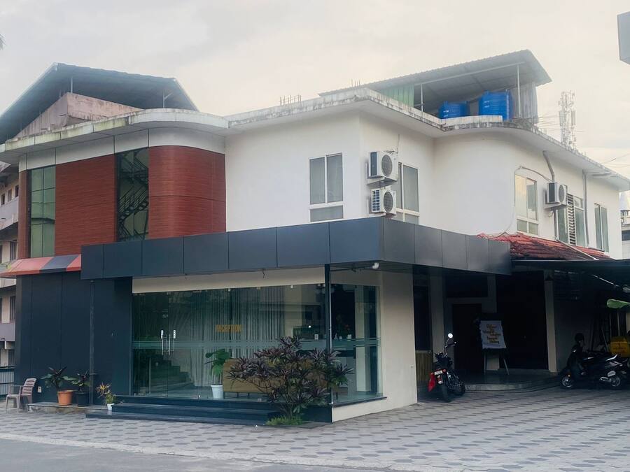 Um edifício moderno com área de recepção, grandes janelas e unidades de ar condicionado.