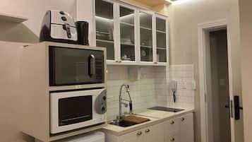 Apartamento Familiar, 1 cama queen-size e sofá-cama, varanda, Vista para a cidade | Cozinha privada | Um micro-ondas, um forno, uma placa de cozinha, utensílios de cozinha
