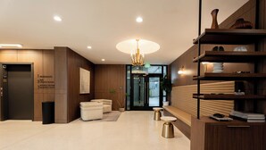 Um hall moderno com balcão de recepção, área de estar e um candelabro.