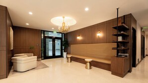 Um lobby moderno com uma receção, área de estar e um candelabro.