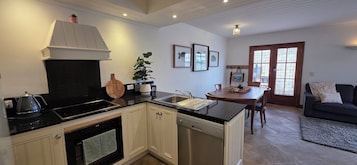 Apartamento Deluxe, vista para o pátio | Cozinha privada | Uma cafeteira/bule, uma chaleira elétrica, mesas de jantar 