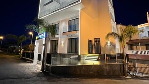 Um edifício moderno de dois andares com fachada de vidro e varanda.