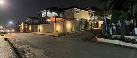 Uma casa de dois andares com varanda e portão fechado.