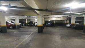Garagem subterrânea com vários níveis, pilares de concreto e vagas demarcadas.