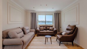 Sala de estar com sofá, poltrona e mesa pequena.