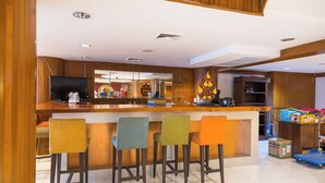 Uma cozinha moderna com espaço para bar, armários de madeira e uma ilha grande com banquetas.