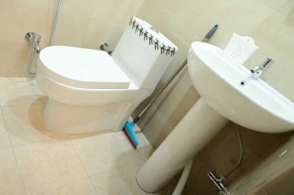 Um banheiro com vaso sanitário, bidê e pia.