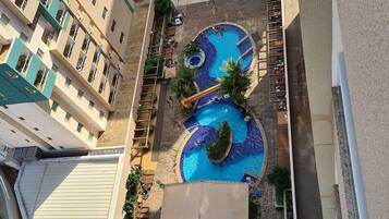 Hotel com vários níveis e área de piscina no terraço, incluindo várias piscinas e um espaço de recreação infantil.