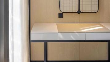 Quarto moderno com piso de madeira, um banco branco e um objeto em forma de grade fixado na parede.