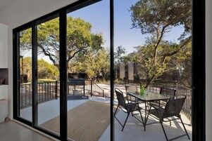 Um pátio moderno ao ar livre com uma porta de vidro que dá para um jardim.