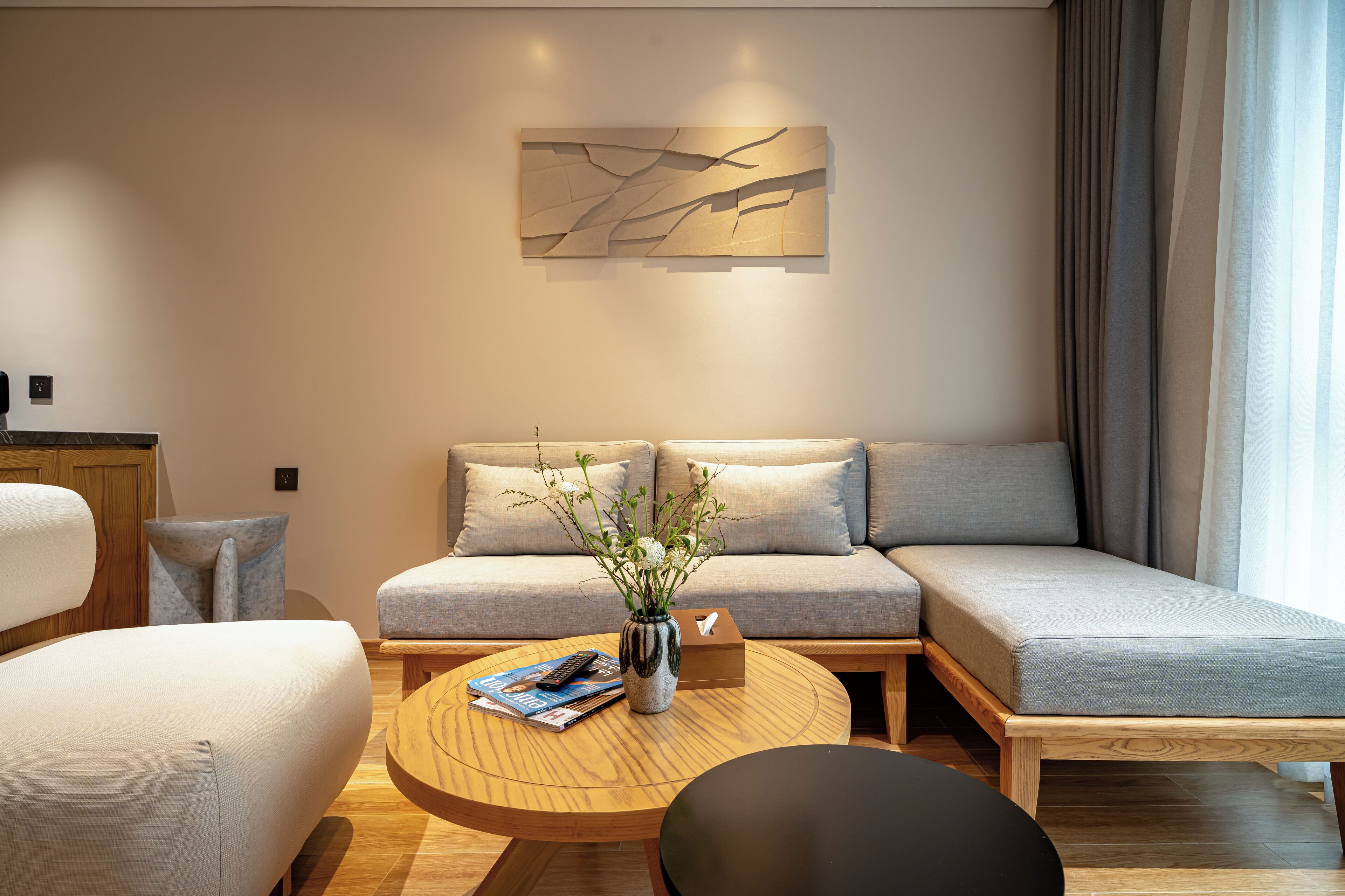 Uma sala de estar moderna com um sofá, uma mesa de centro e um vaso com flores.