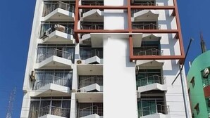 Um edifício de vários andares com varandas e uma placa com a inscrição 'Mermaid Baywatch Resort'.