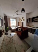 Uma sala de estar moderna com um sofá, uma mesa de centro e um ventilador de teto.