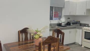 Quarto quádruplo standard, vista para a piscina | Área de estar | TV