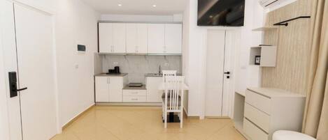 Um apartamento compacto e moderno, com cozinha compacta, área de refeições e banheiro pequeno.