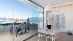 Uma zona de refeições moderna com parede de vidro e vista para uma marina.