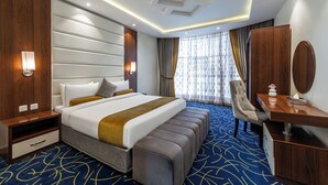 Quarto de hotel moderno com uma cama grande, uma escrivaninha e uma cadeira.