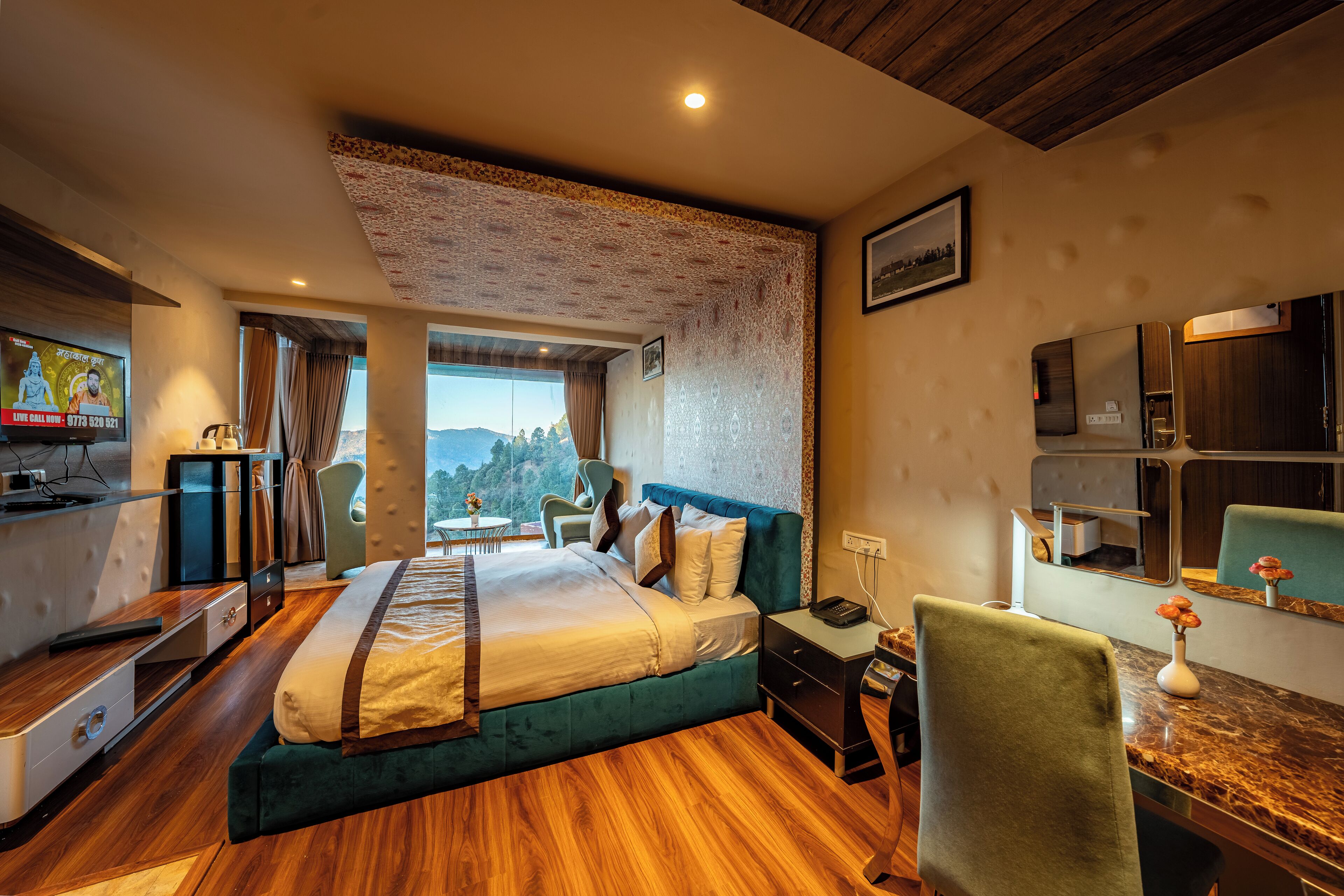 Quarto de hotel moderno com uma cama grande, uma escrivaninha, uma televisão e vista para as montanhas.