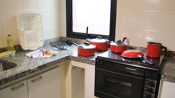 Apartamento família, sacada | Cozinha privada | Geladeira, micro-ondas, fogão, talheres/pratos/utensílios de cozinha