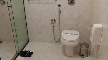 Um polibã e uma banheira separados, um secador de cabelo, roupões