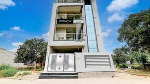Um edifício moderno de vários andares com uma placa que diz 'Renaya' no segundo andar.