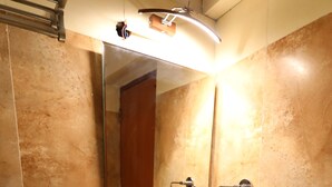 Casa de banho com lavatório, espelho, porta-toalhas e dispensador de sabonete.
