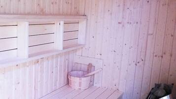 Uma sala de sauna com paredes de madeira e um banco.