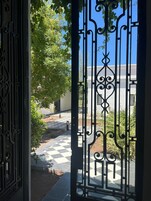 Uma entrada com portão e um caminho quadriculado que leva a um edifício.