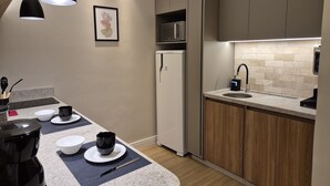Cozinha moderna com micro-ondas, pia e armários de madeira.