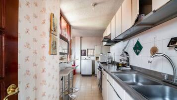 Um frigorífico, um micro-ondas, uma cafeteira/bule, uma torradeira