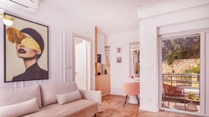 Uma sala de estar moderna com um sofá, uma mesa de centro e um espaço de jantar com uma cadeira e mesa.