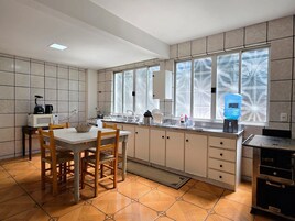 Geladeira grande, micro-ondas em uma área comum, fogão, liquidificador