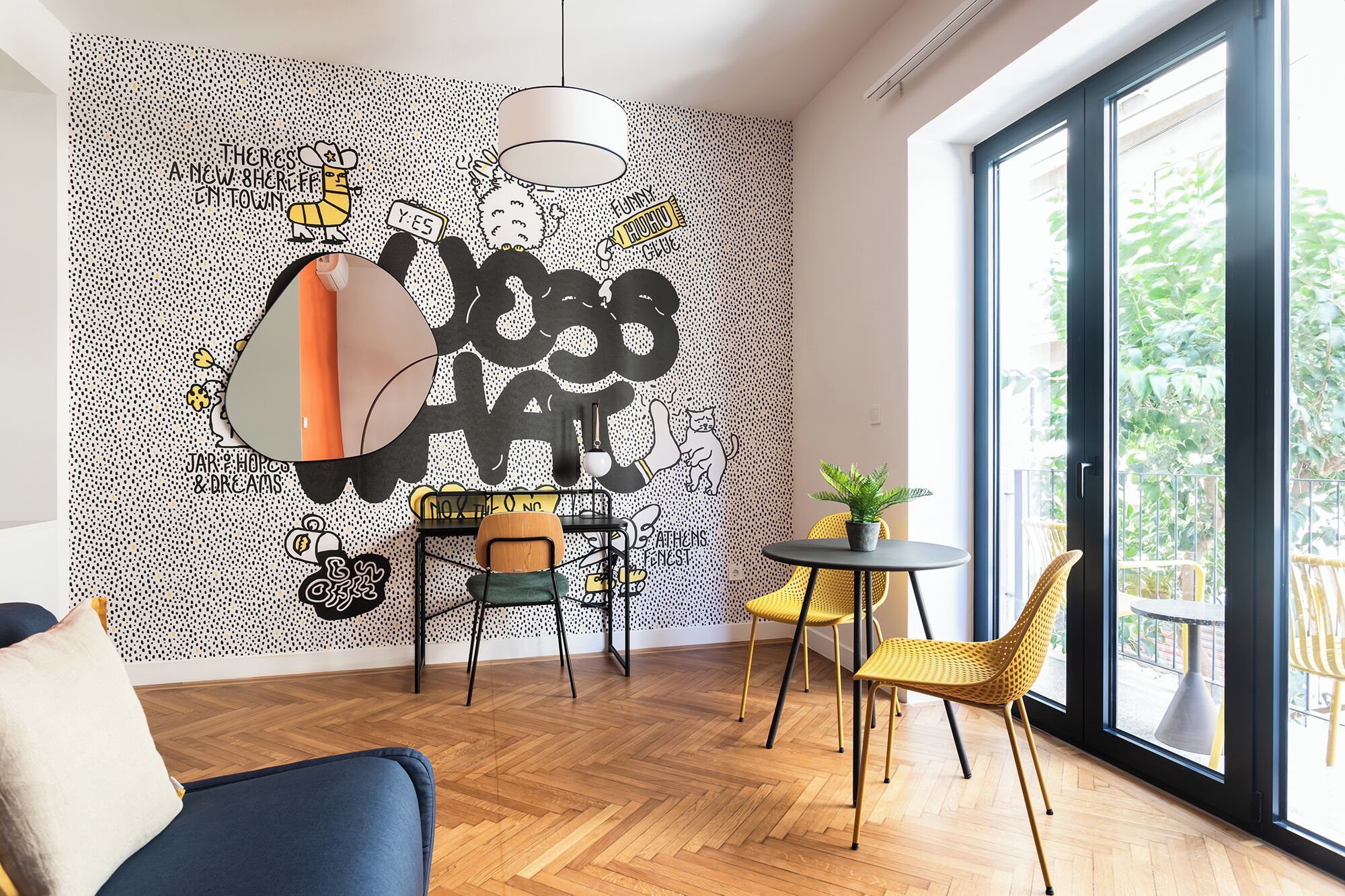 Uma sala de estar moderna com piso em padrão herringbone, uma área de jantar com mesa redonda e cadeiras, e uma grande janela com vista para o verde.