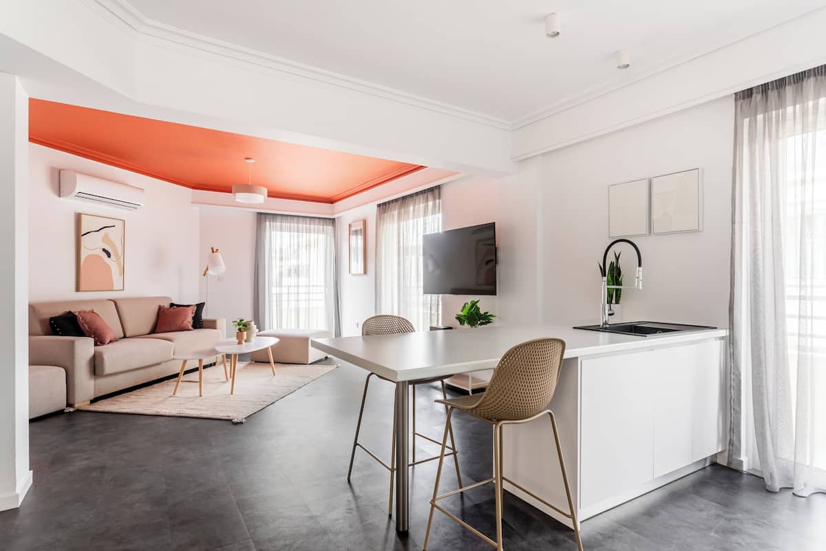 Uma sala de estar moderna com sofá, mesa de centro e área de jantar.