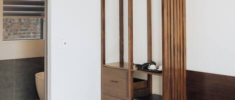 Um banheiro moderno com teto de madeira, luminária pendente, vaso sanitário e um pequeno armário.