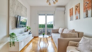 Uma sala de estar moderna com sofá, televisão e obras de arte na parede.