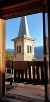 Varanda com torre de pedra e vista desobstruída das montanhas.