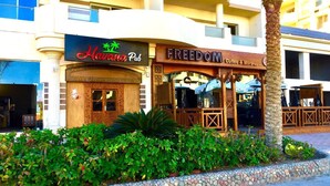 Um edifício com um 'Havana Pub' e 'FREEDOM Coffee & More' no andar térreo.