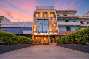 Um hotel moderno com entrada imponente, fachada de vidro ampla e terraço no terraço.