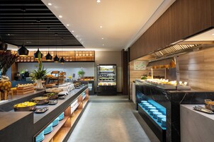 Uma mesa de buffet moderna com diversas estações de comida, um refrigerador e um balcão de mármore.