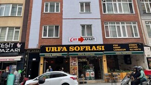 Um edifício de vários andares com uma placa indicando 'URFA SOFRASI', sinalizando um restaurante ou café.